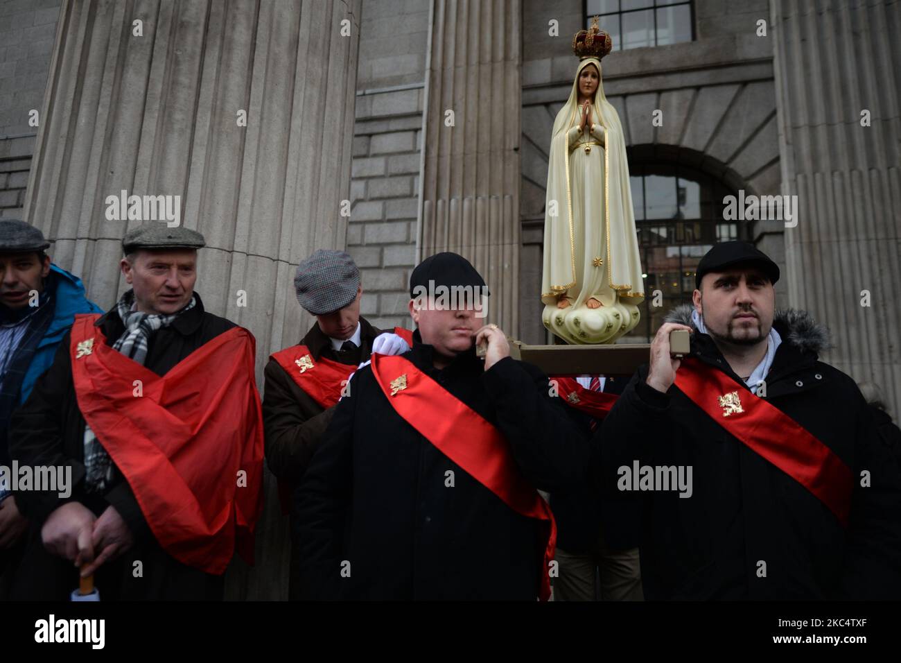 A group of men holds a statue of 'Our Lady' during a 'Rosary Rally ...