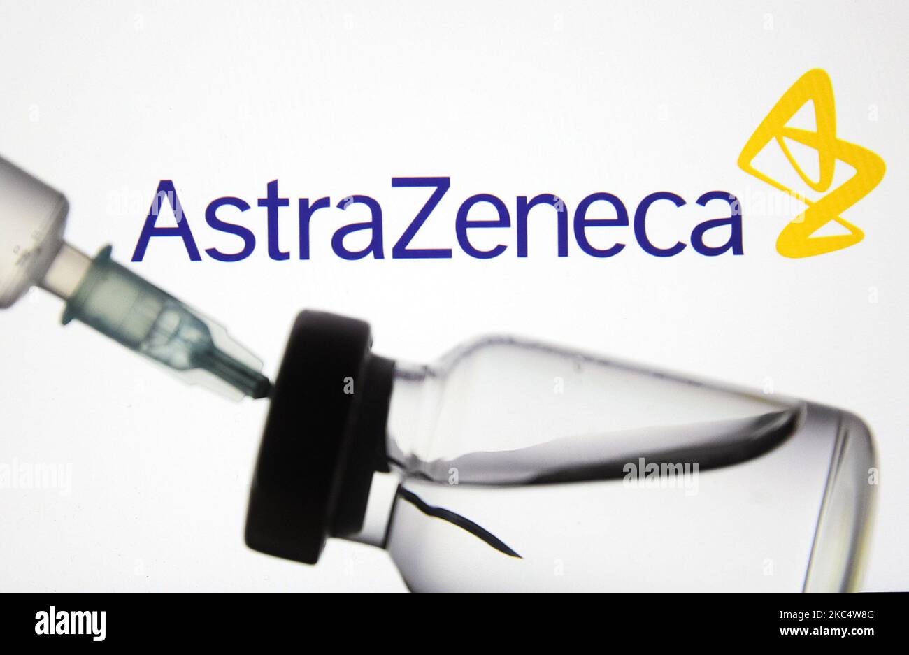 A medical syringe and a vial in front of the AstraZeneca ...