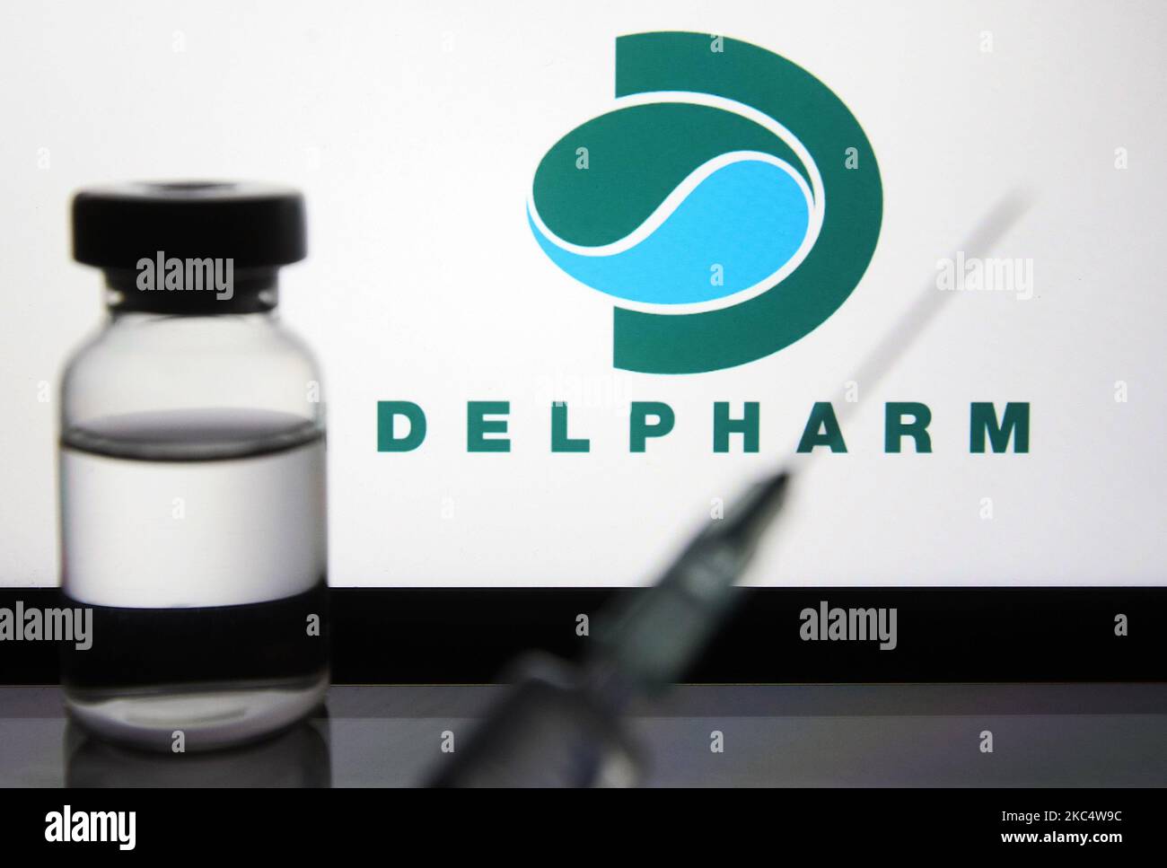 A medical syringe and a vial in front of the Delpharm logo are seen in ...