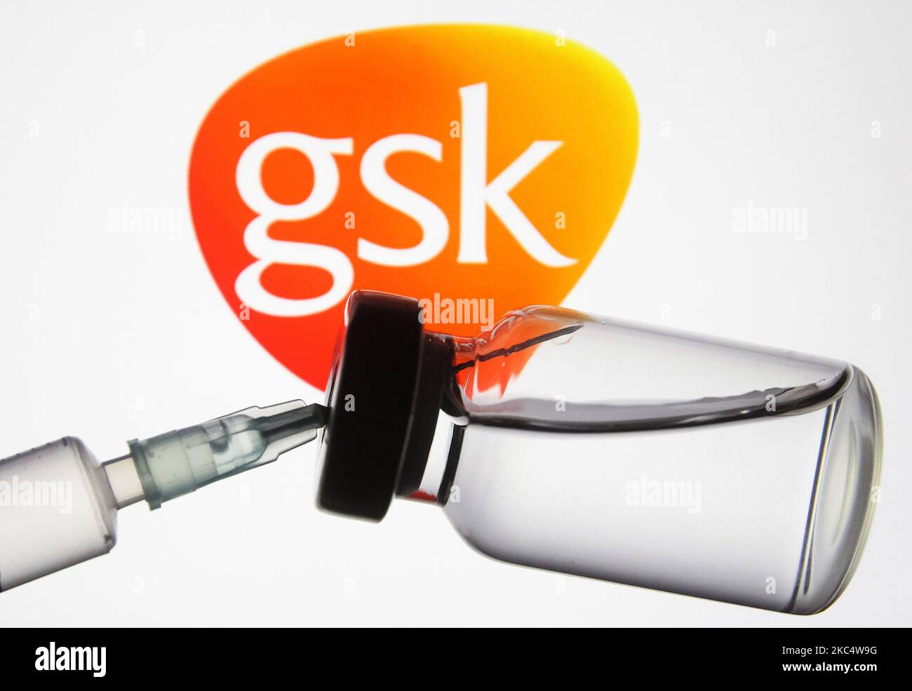 A medical syringe and a vial in front of the GlaxoSmithKline (GSK ...