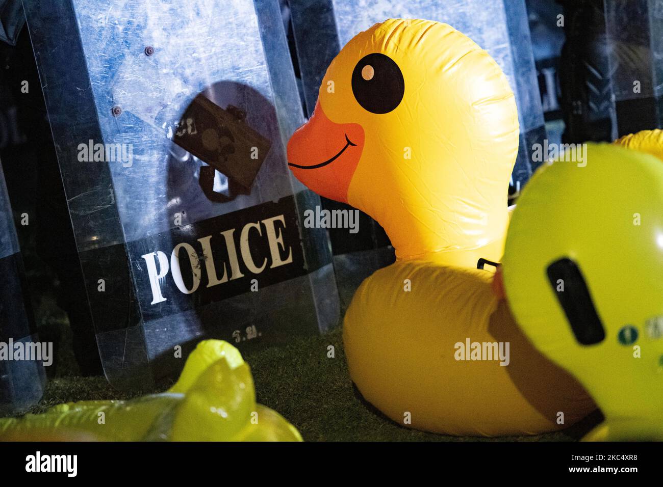 An inflatable rubber ducks in front of riot police during a protest to ...