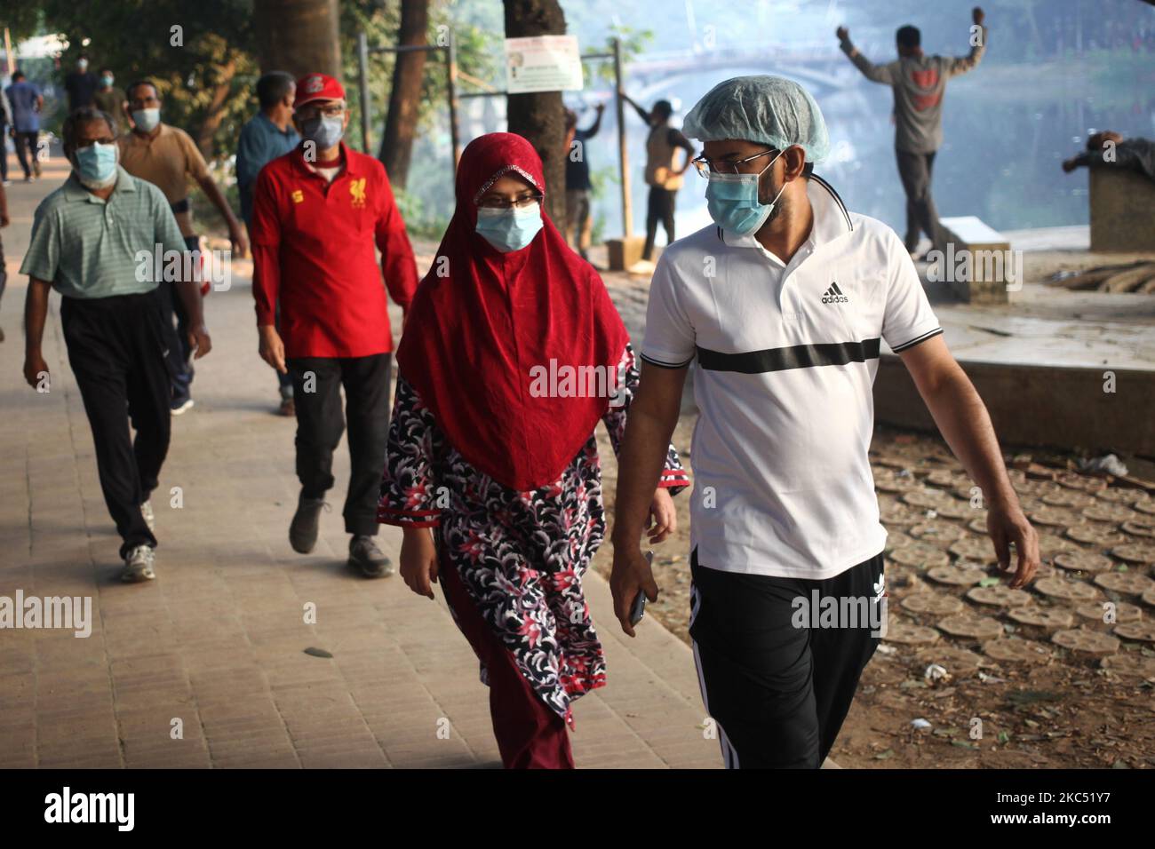 Health-conscious people wear mask as they exercise at Dhanmondi Lake ...