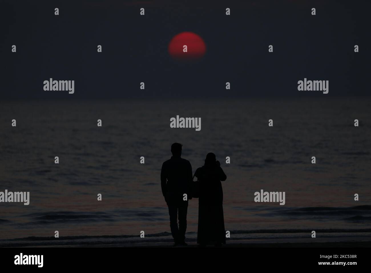 A couple observes the beauty of sunset at Kuakata sea beach in ...