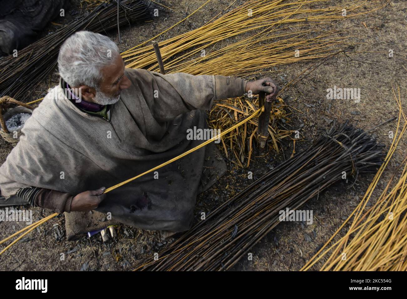 A Kashmiri worker peel off the skin from boiled twigs to make a "Kangri ...