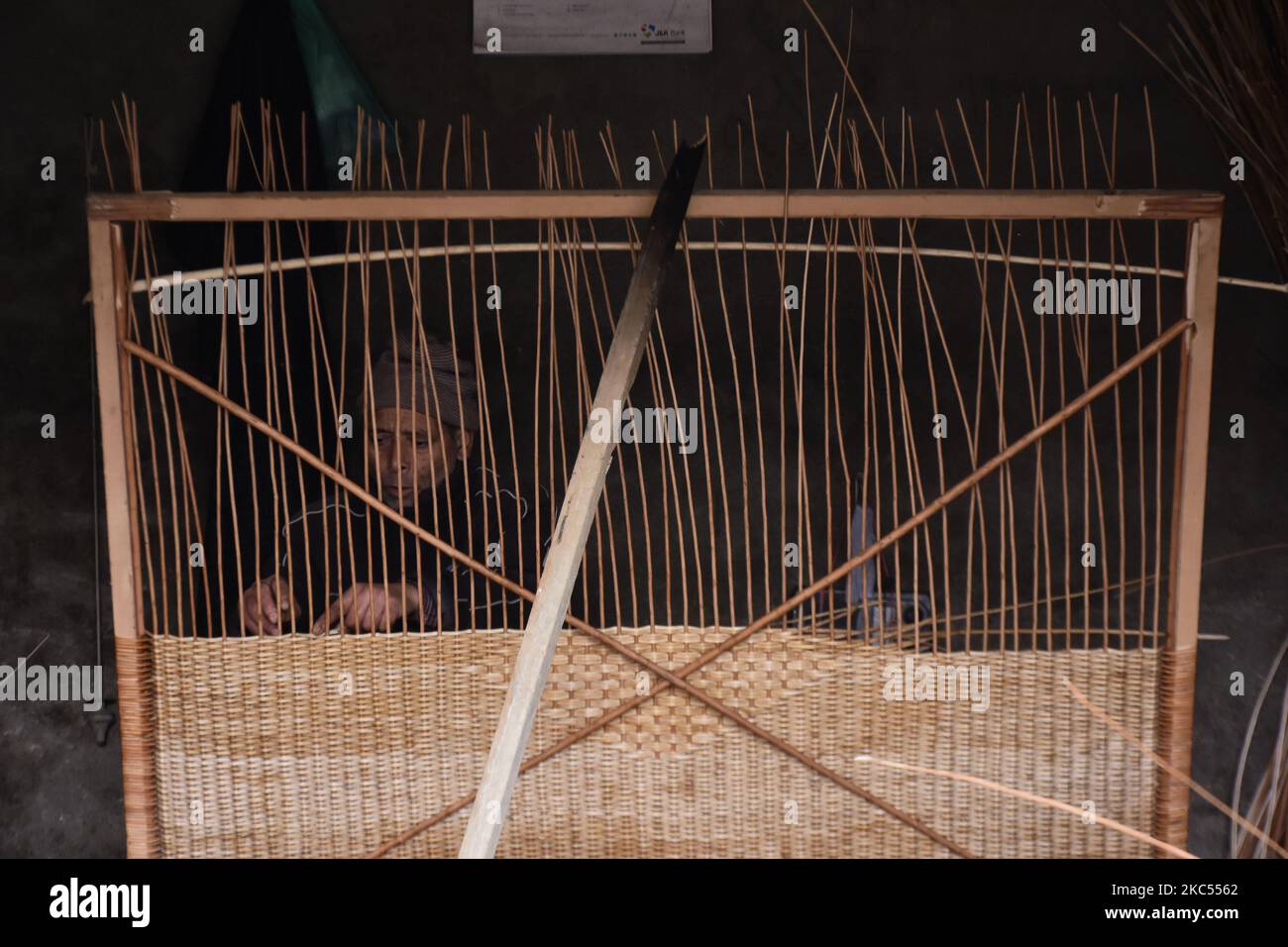 An artisan weaves a room seperator with wicker sticks in Dargah area of ...