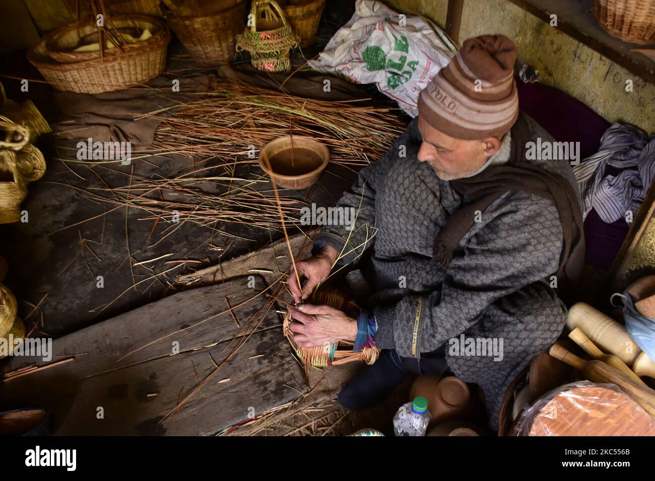 A Kashmiri artisan makes a "Kangri", a traditional firepot with twigs ...