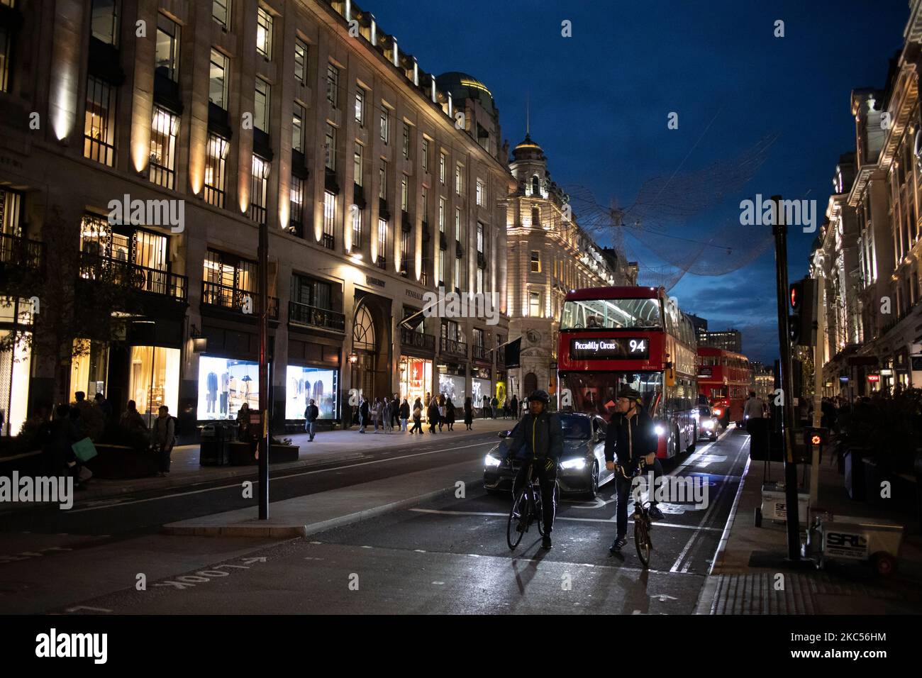 Cyclists line up ahead of traffic on Regent Street during twilight as ...