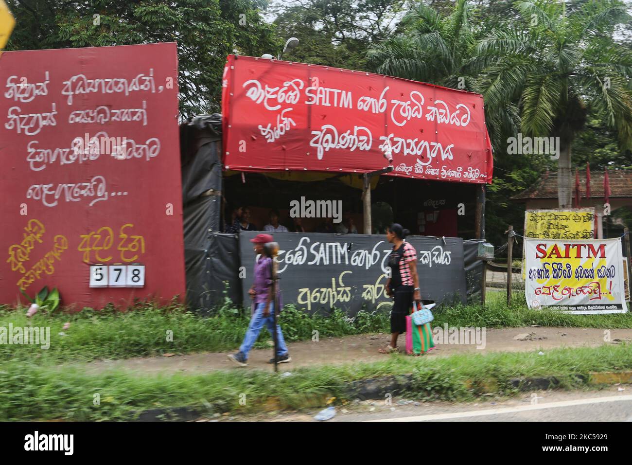 People walk past political banners in the city of Kandy, Sri Lanka ...