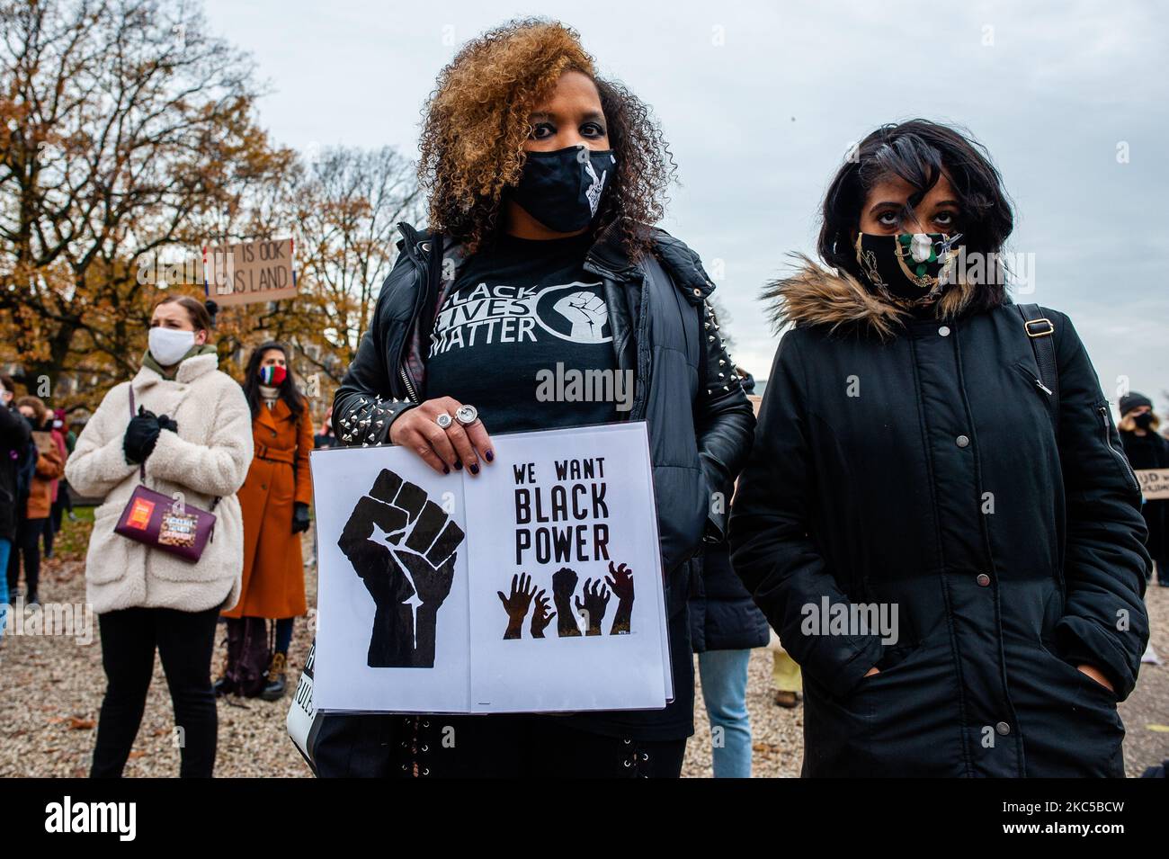 Two Black women are holding placards against racism, during the ...