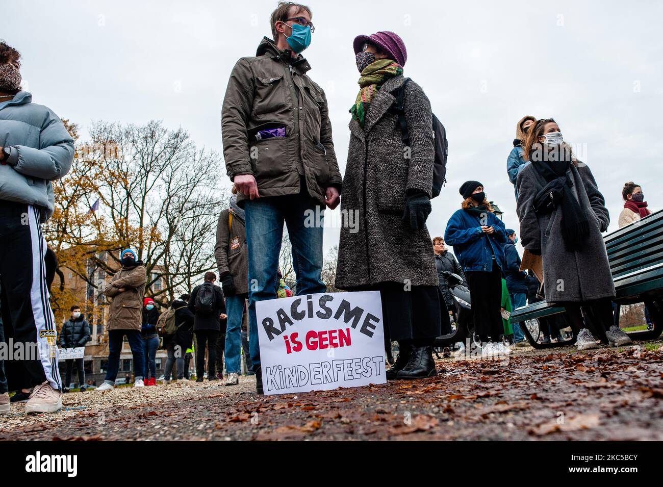 A couple are talking while an against racism placard is placed on the ...
