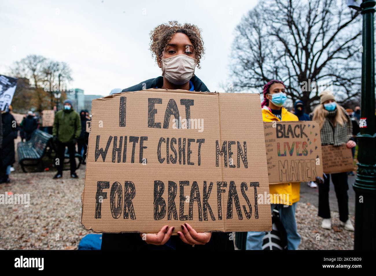 A Black woman is holding a feminist placard, during the demonstration ...