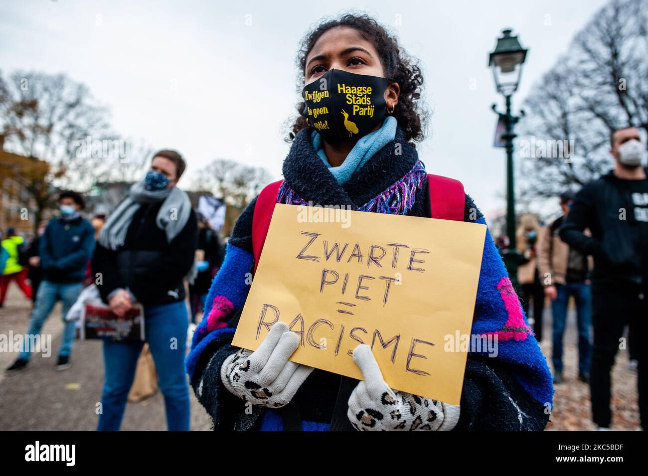 A Black woman is holding a Dutch placard that says Black Pete is racism ...