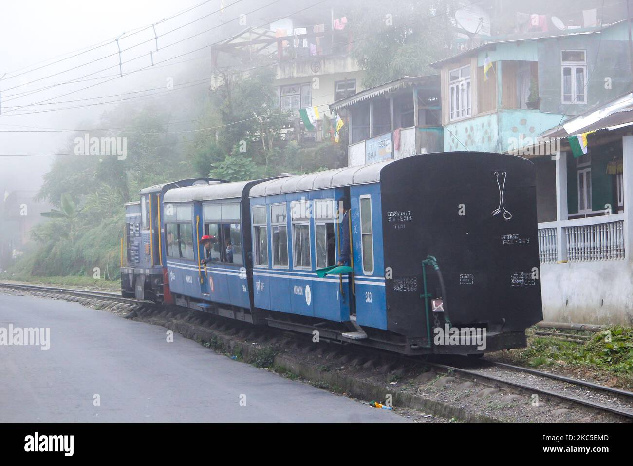 The small train passes next to the houses. The Darjeeling Himalayan ...