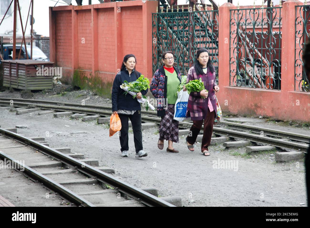 Women who live next to the rails are seen walking between them. The ...
