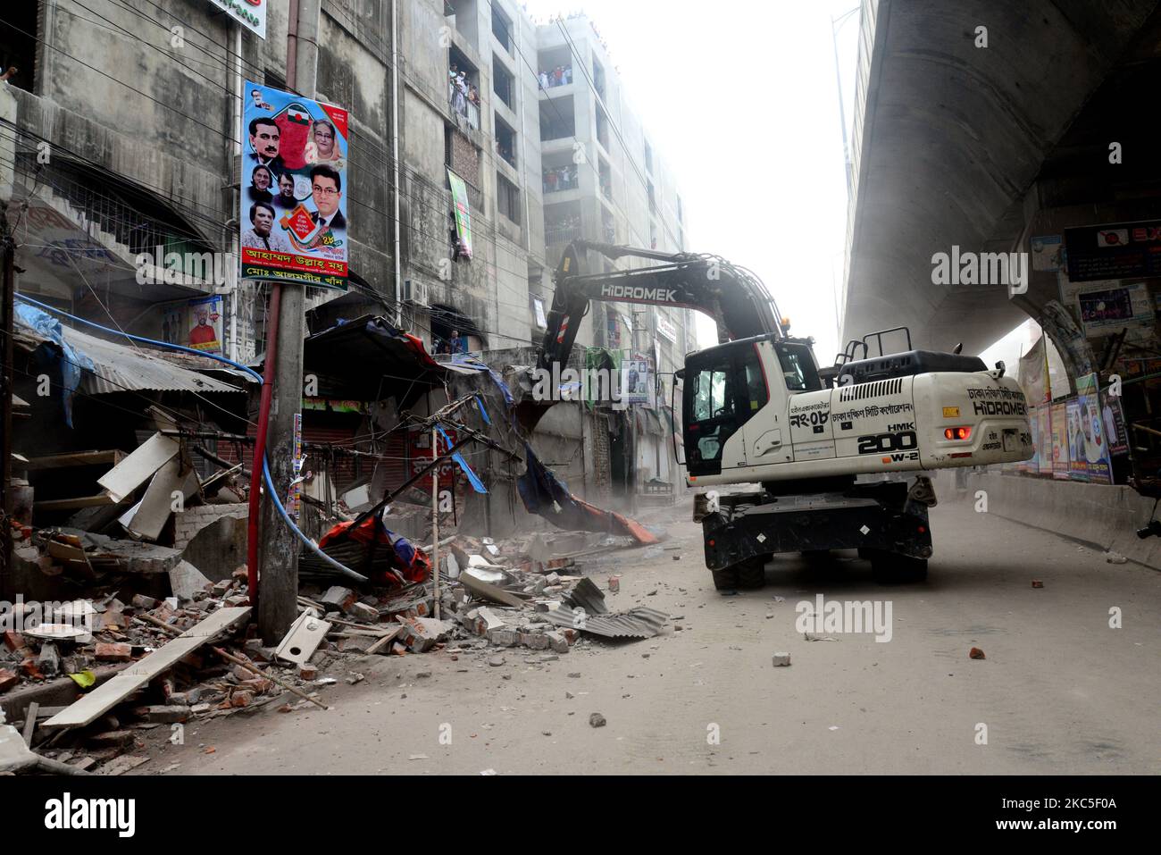 A bulldozer from Dhaka South City Corporation demolishes illegal shops ...