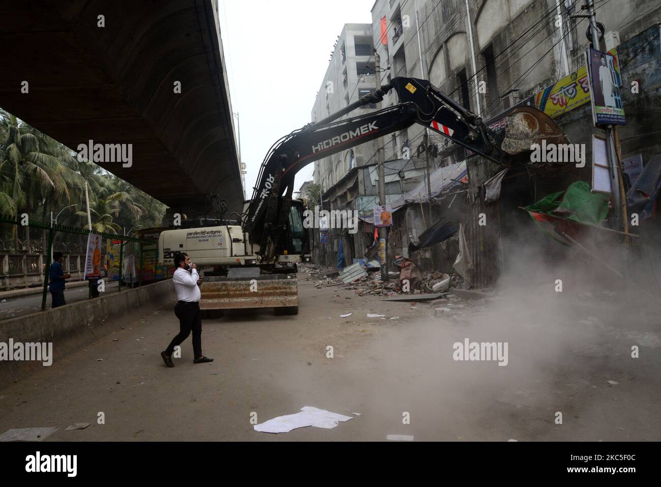 A bulldozer from Dhaka South City Corporation demolishes illegal shops ...