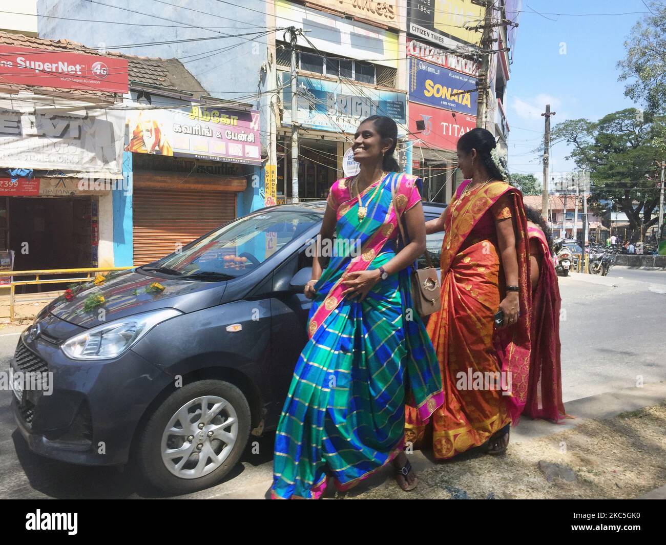 Women wearing colourful sarees walk along a road in Nagercoil, Tamil ...