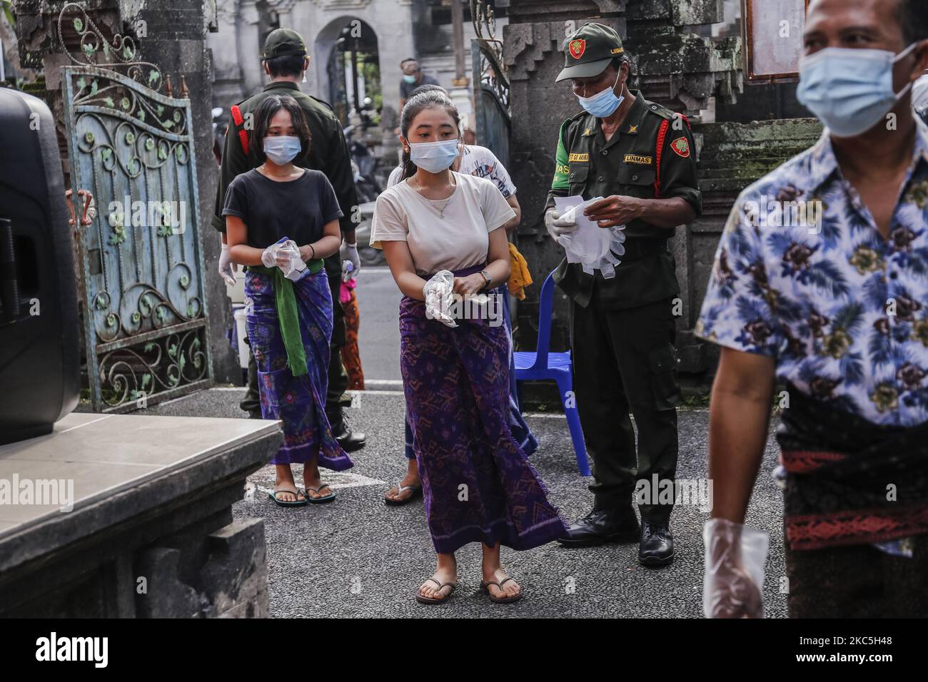 Balinese wears plastic gloves before voting during regional election amid COVID-19 pandemic at ...