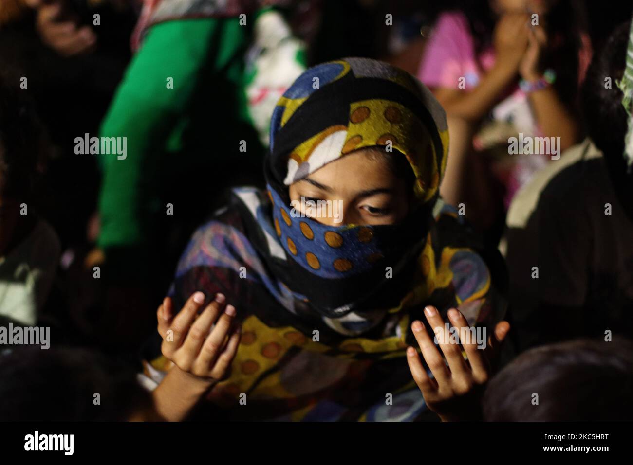 Hundreds of women and girls are seen praying on the road after the ...