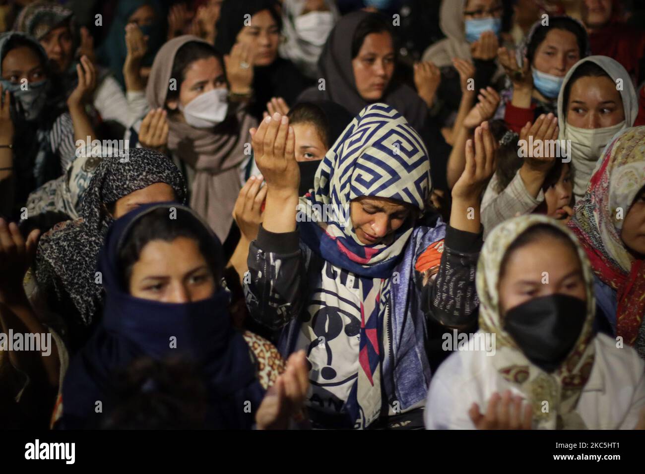 Hundreds of women and girls are seen praying on the road after the ...