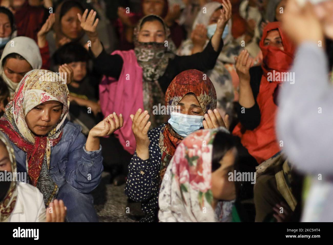 Hundreds of women and girls are seen praying on the road after the ...