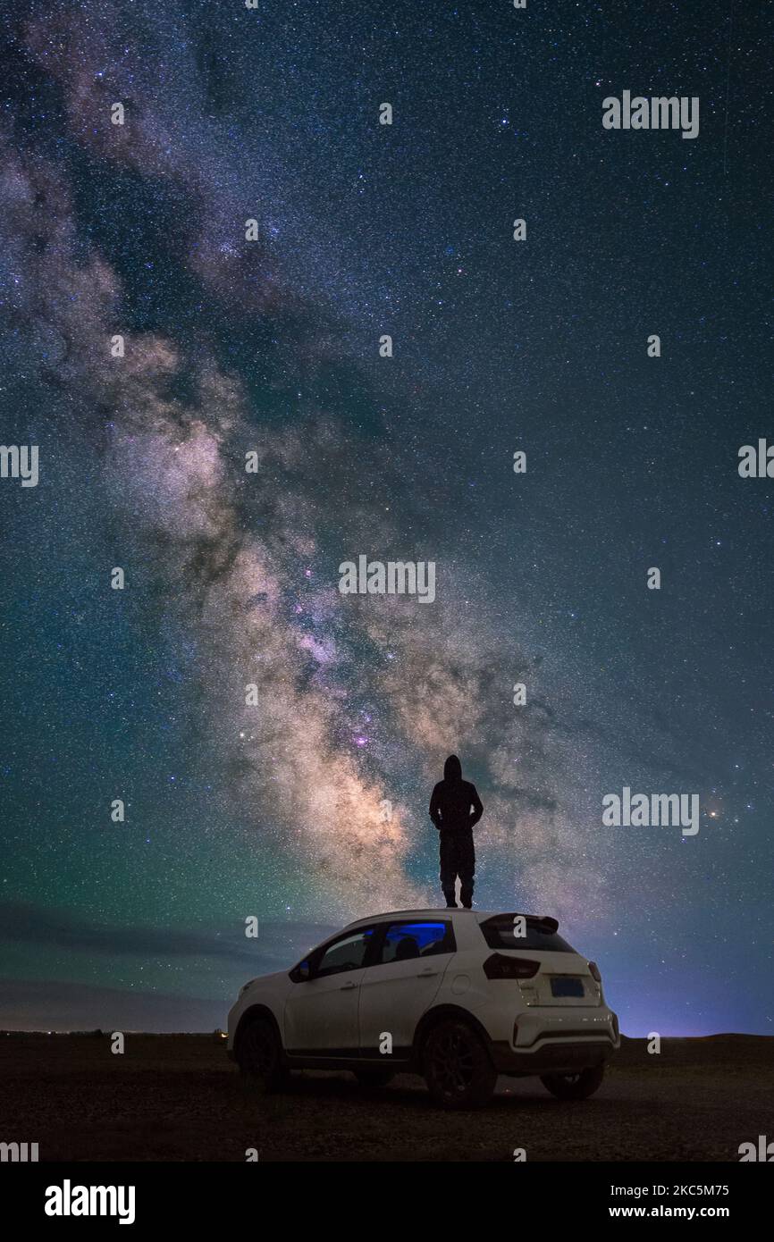 A man in a car the lights on and nebulas and galaxies in the dark ...