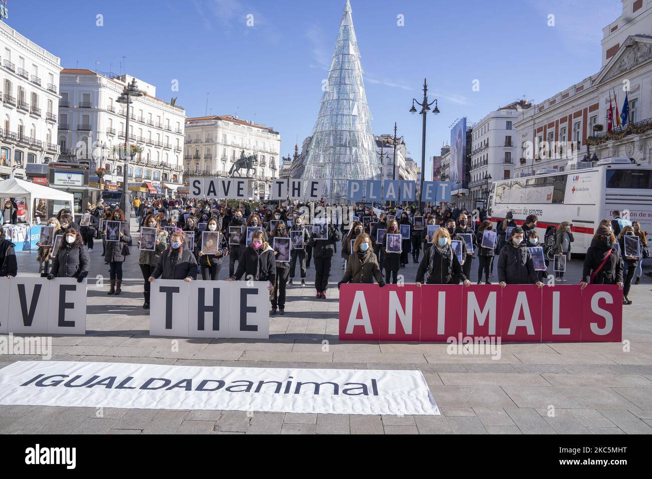 Participants in the Animal Equality rally hold posters with pictures of ...