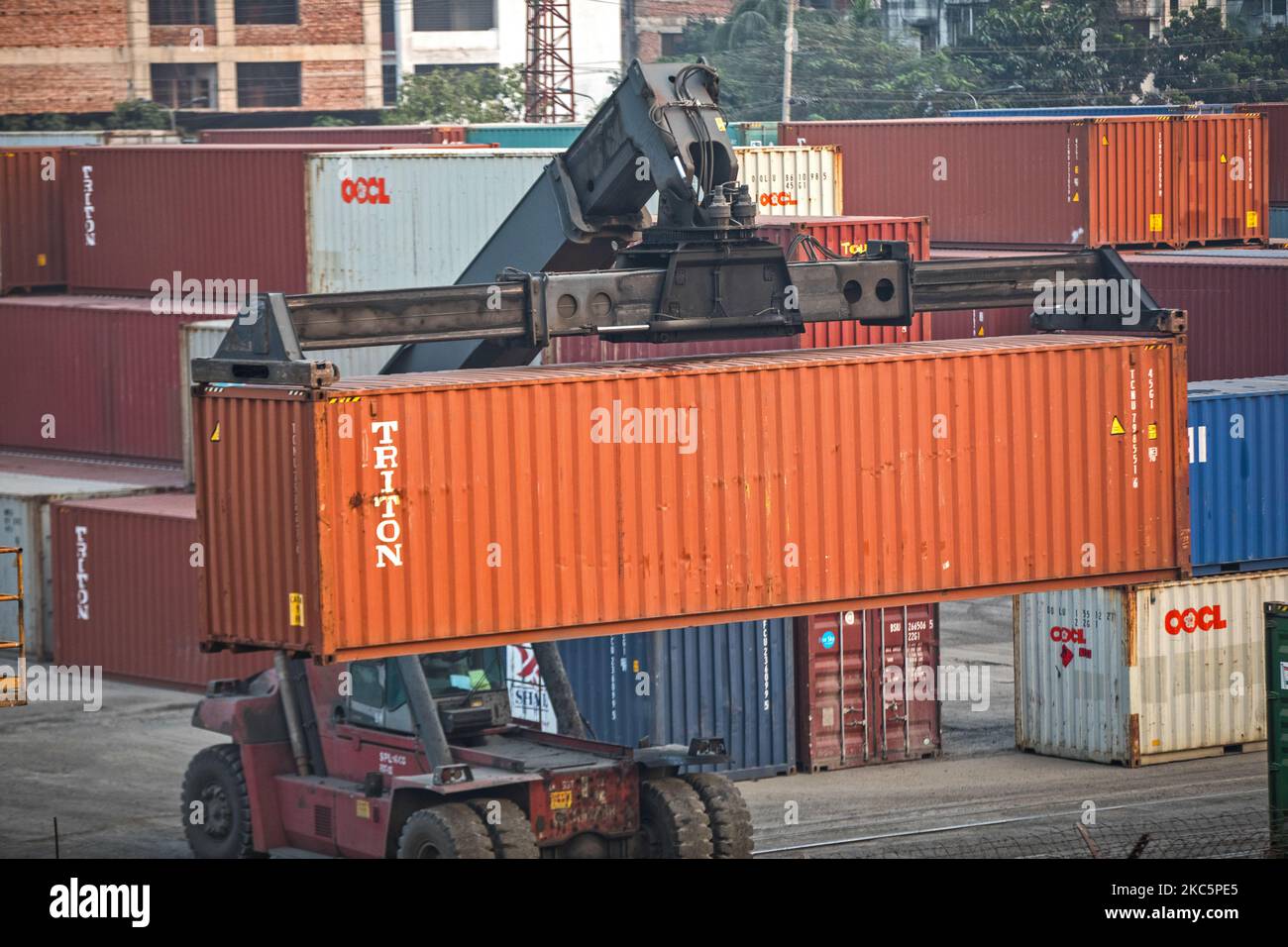 Workers drive a container loader at the Inland Container Depot in ...