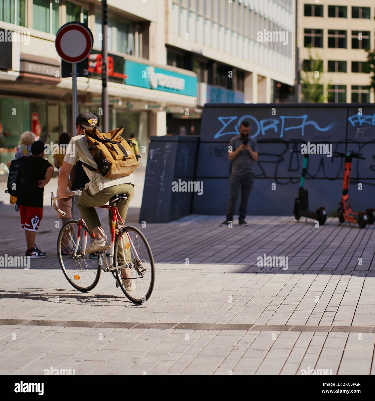 A man with a backpack riding a bike in the city Stock Photo - Alamy