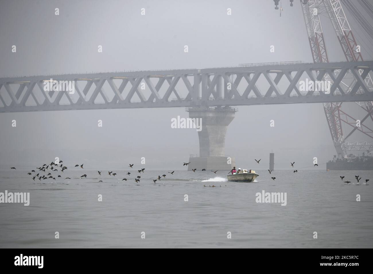 Birds fly near the Padma Bridge which is under construction over its ...