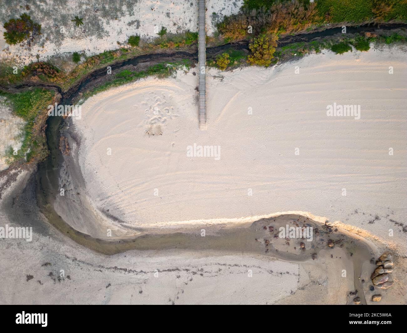 Small river stream flowing to the ocean through a sand beach Stock ...