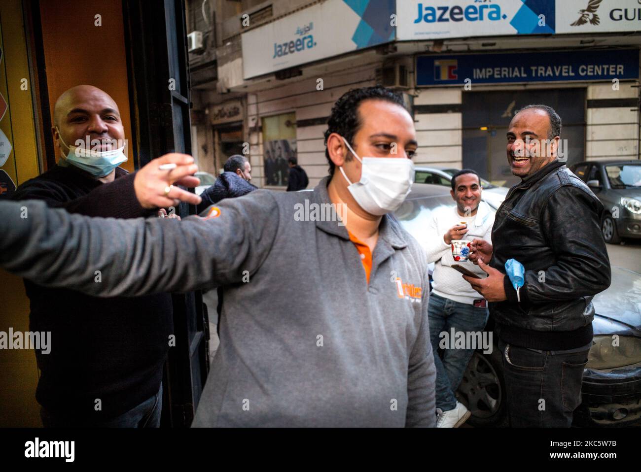 Egyptian men having fun in front of their shops in a small road near ...