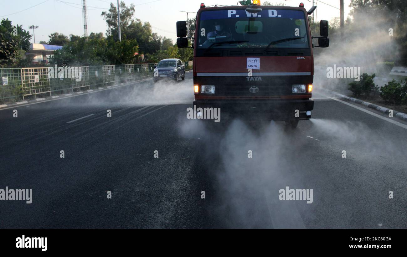 A municipal truck uses anti-smog gun to spray water on the road for ...