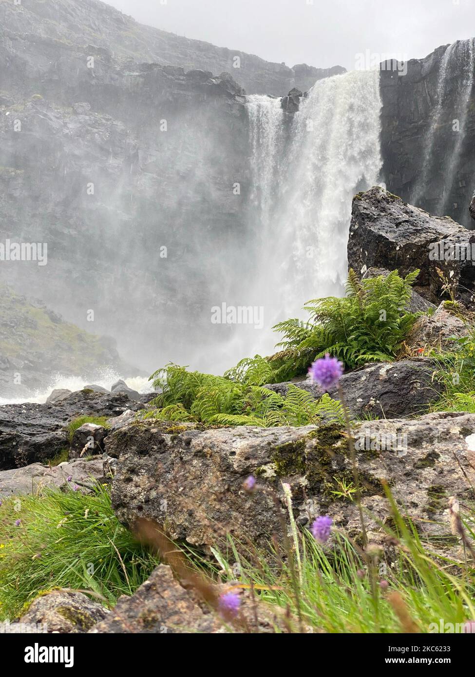 A vertical shot of a waterfall on a cliff in Faroe Islands Stock Photo ...