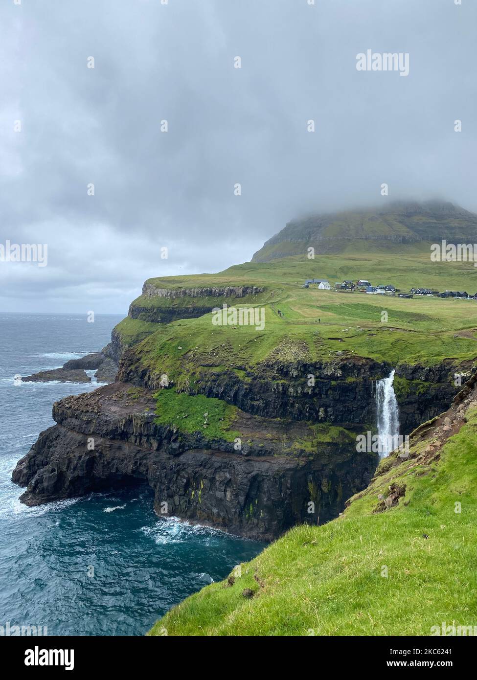 A vertical shot of a waterfall on a cliff in Faroe Islands Stock Photo ...