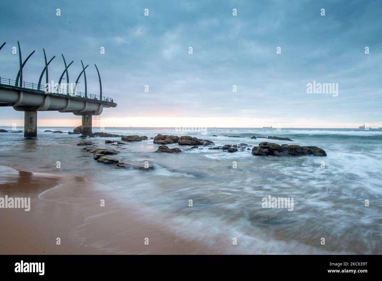 A bridge on the sea with a sunset background Stock Photo - Alamy