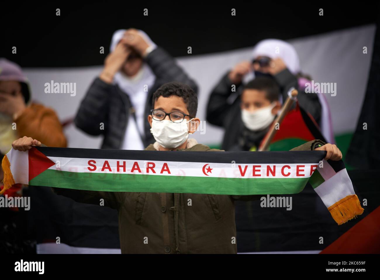 A boy holds a scarf reading 'sahara will win'. Sahrawi people of ...