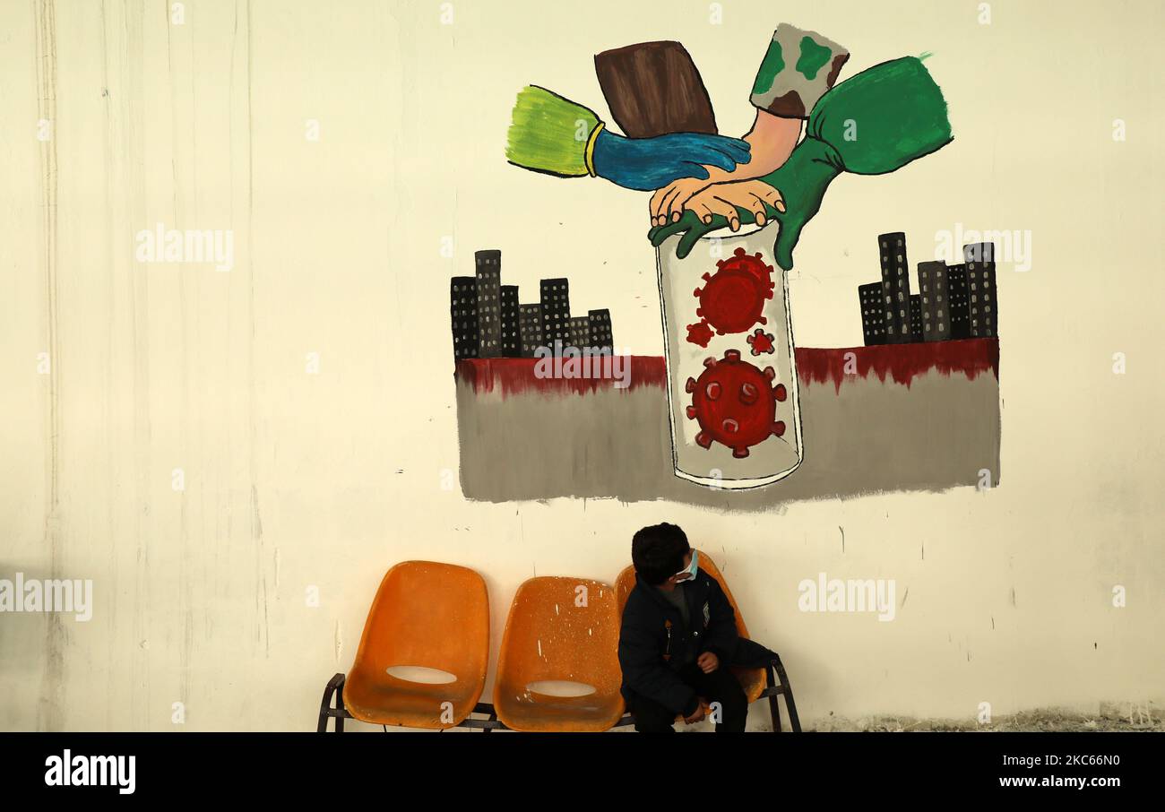 A Palestinian child sits beneath graffiti depicting medical workers ...