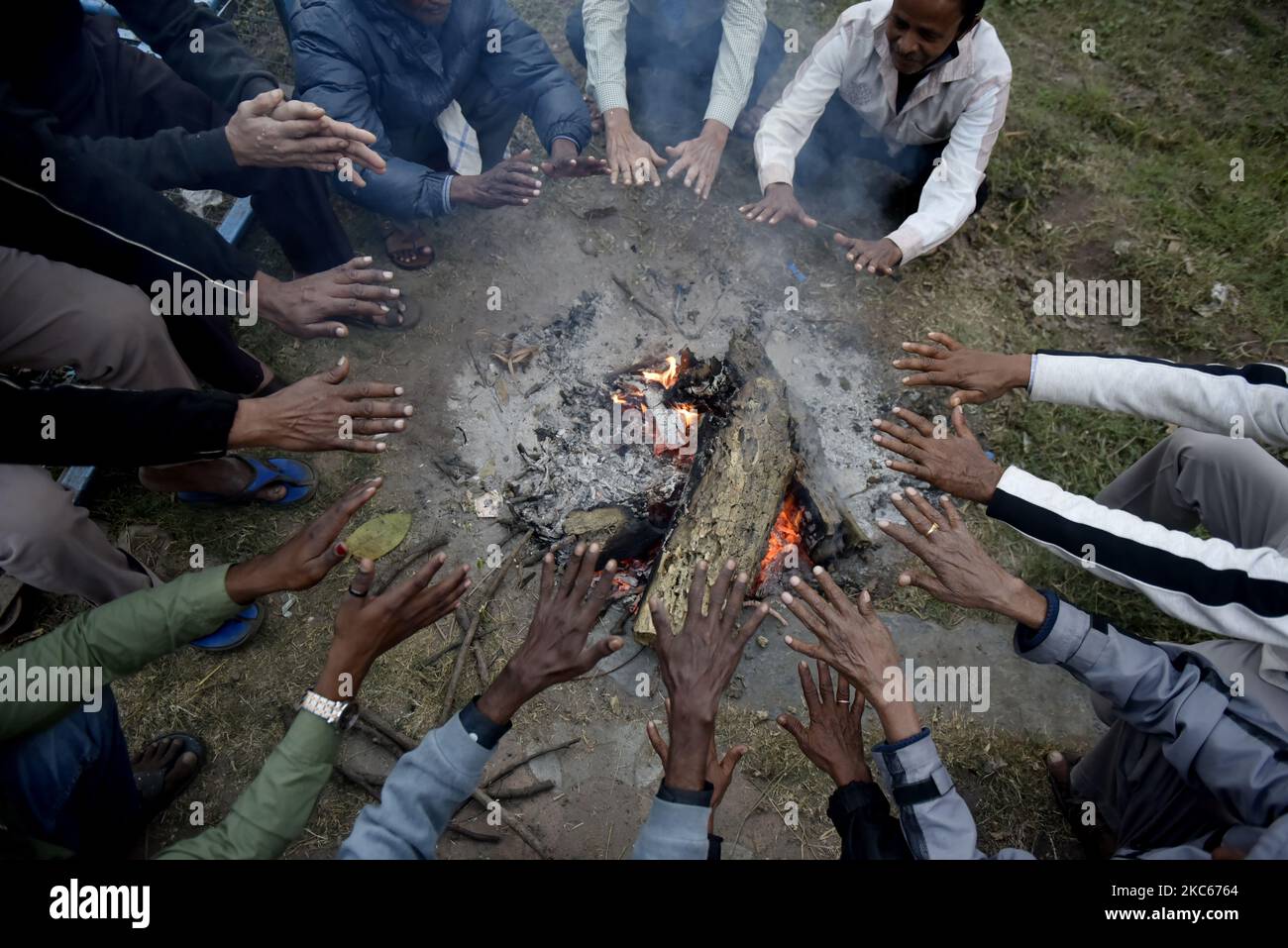 People sit beside the fire for comfort as the temperature dips down to ...