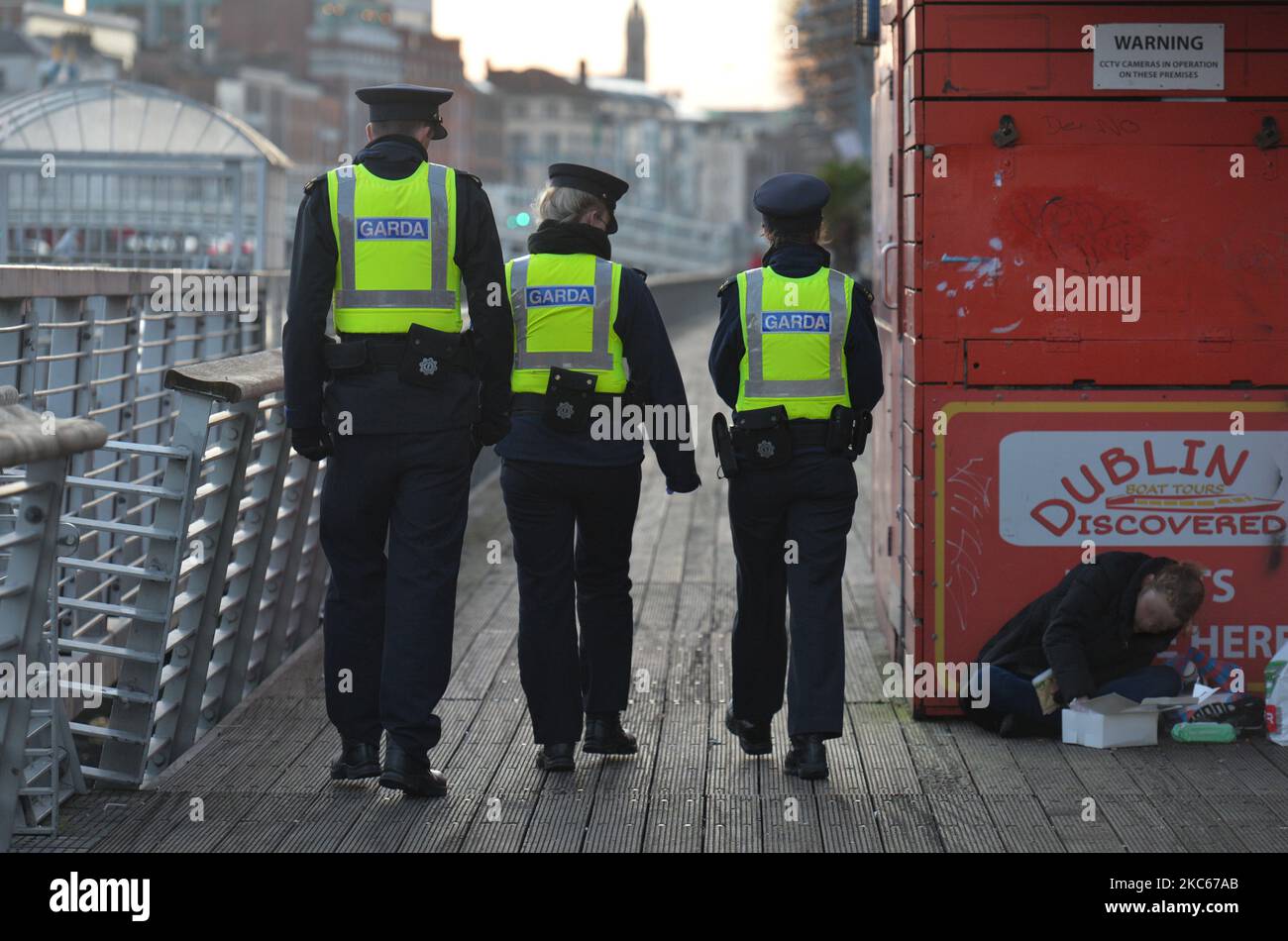 Members of the Garda (Irish Police) walk by a homeless person, in ...