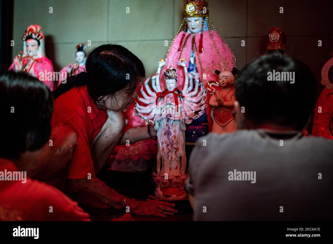 A worshiper cleans a statue at Toasebio Temple in Glodok, West Jakarta ...