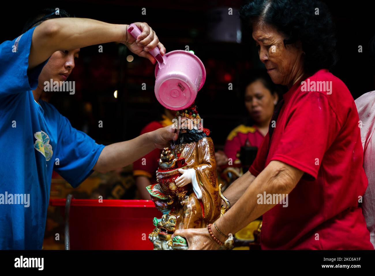 A worshiper cleans a statue at Toasebio Temple in Glodok, West Jakarta ...