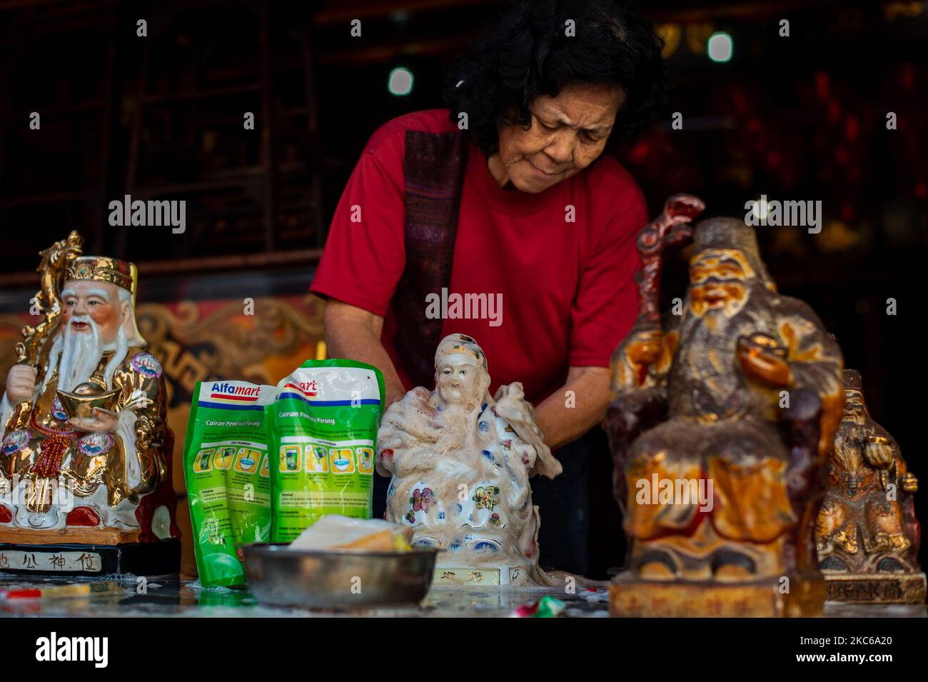 A worshiper cleans a statue at Toasebio Temple in Glodok, West Jakarta ...