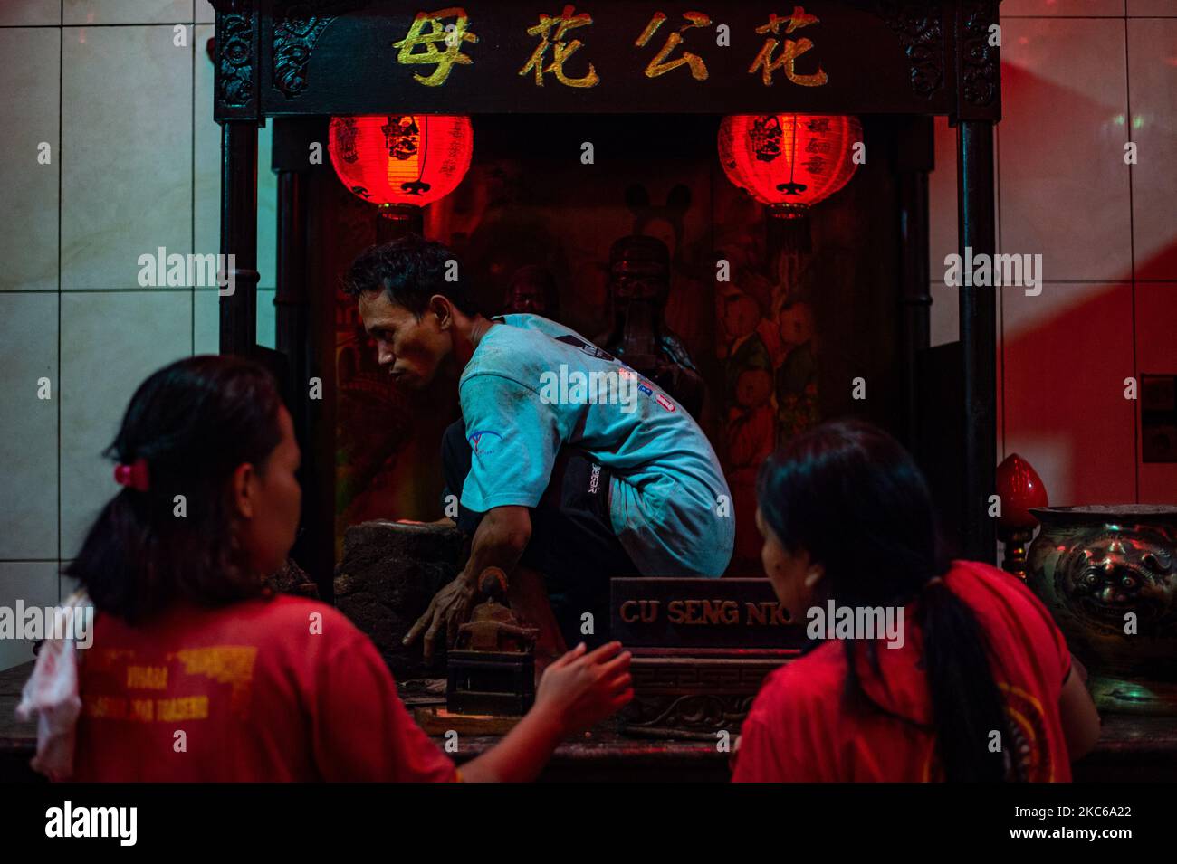 A worshiper cleans a statue at Toasebio Temple in Glodok, West Jakarta ...