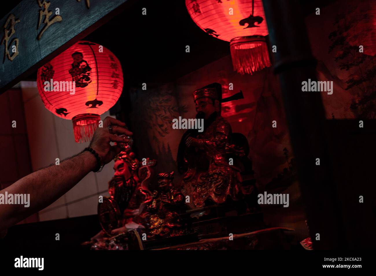 A worshiper cleans a statue at Toasebio Temple in Glodok, West Jakarta ...