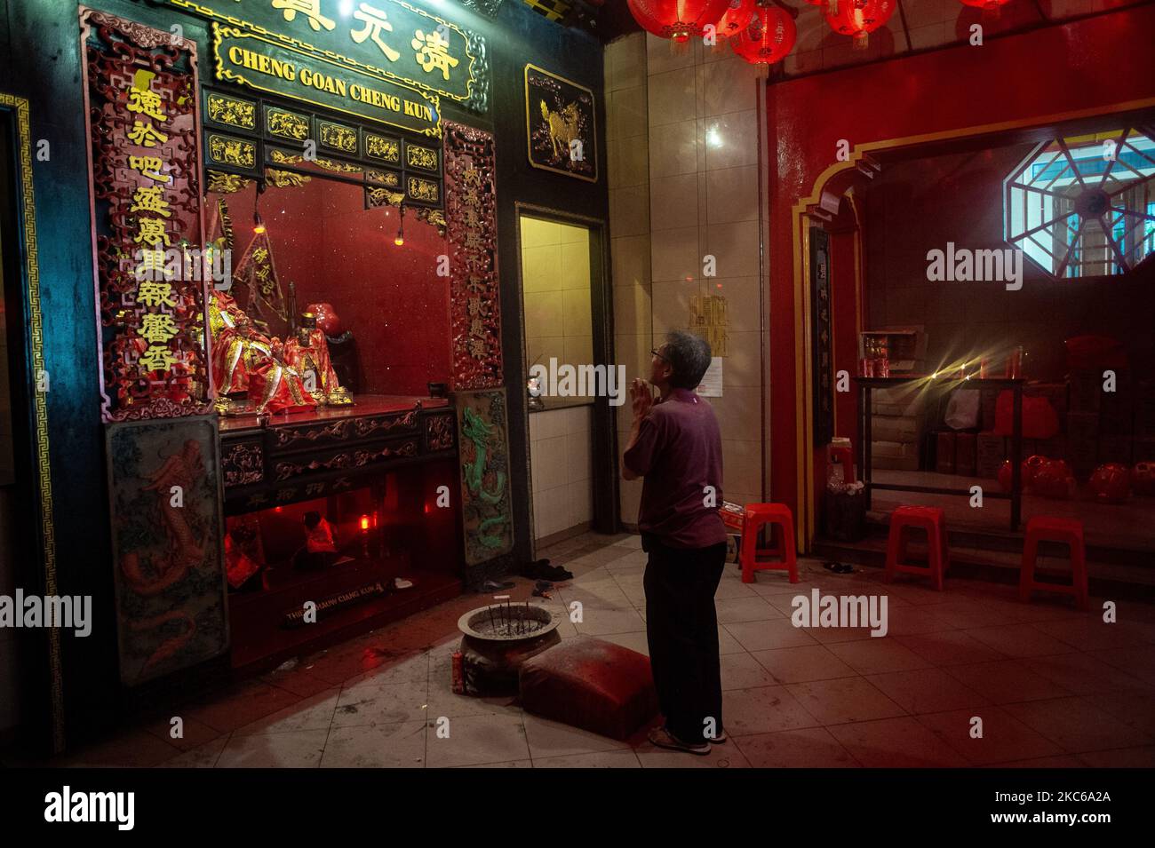 A worshiper cleans a statue at Toasebio Temple in Glodok, West Jakarta ...