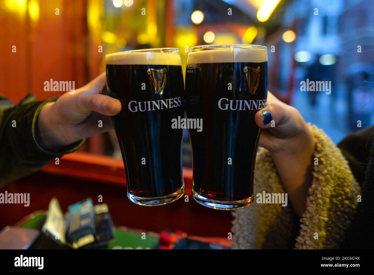People enjoy a pint of Guinness on a bar-restaurant terasse in Dublin's ...