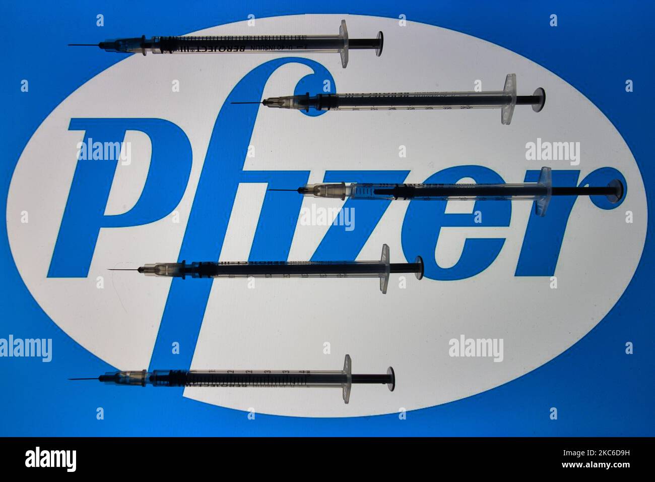 An illustrative photo showing medical syringes seen in front of Pfizer ...