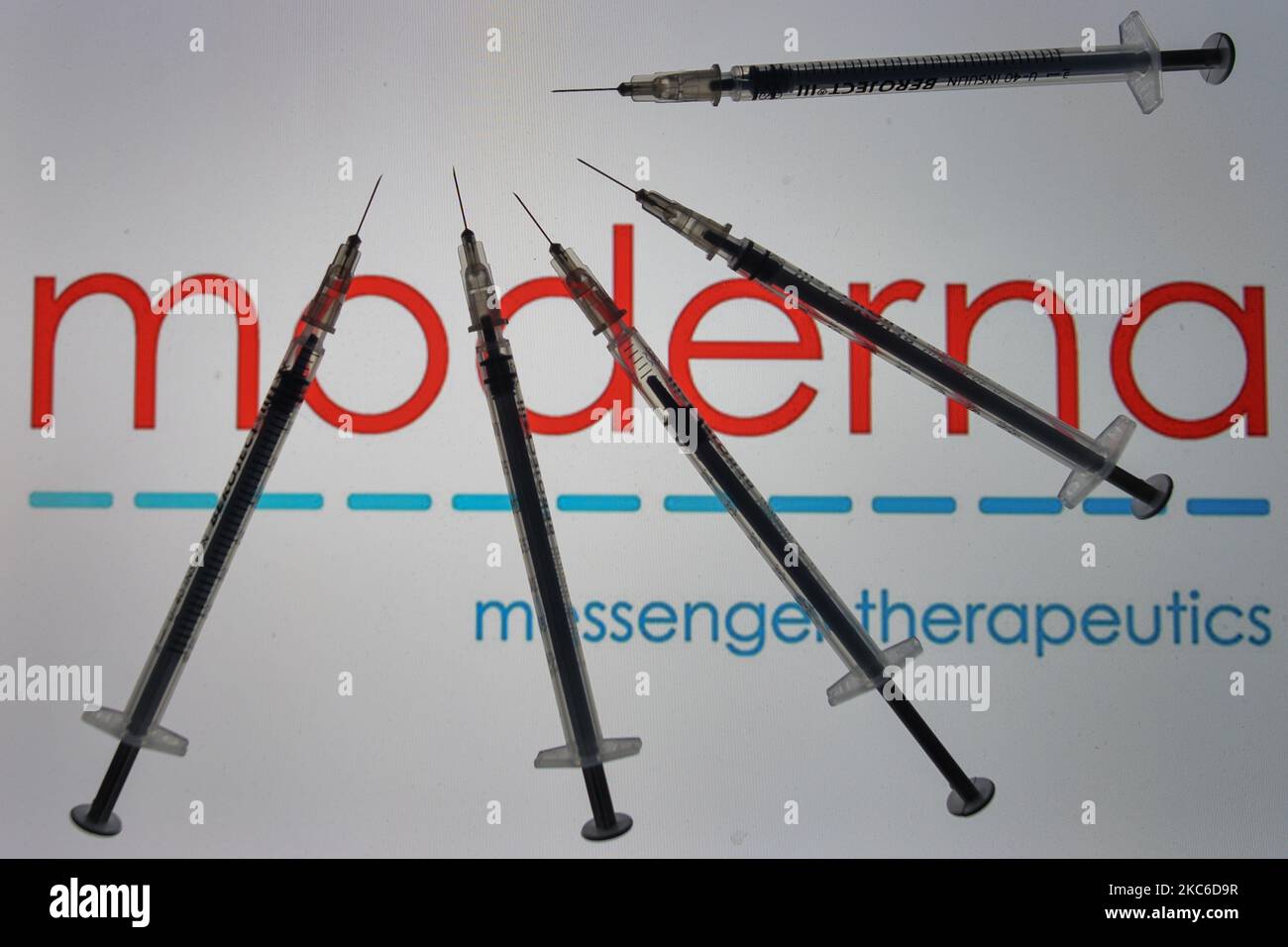 An illustrative photo showing medical syringes seen in front of Moderna ...
