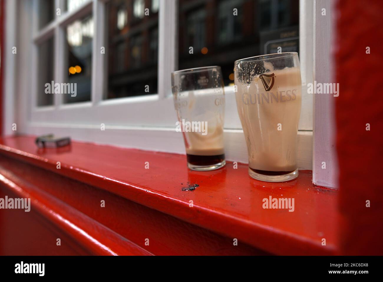 Two empty pints of Guinness seen in a window outside a closed pub in ...